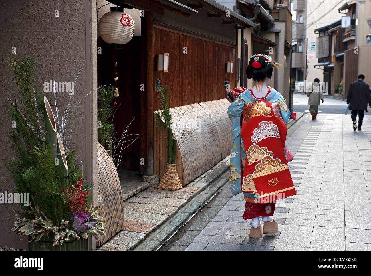 A Japanese maiko, or apprentice geisha or geiko, walking along a ...