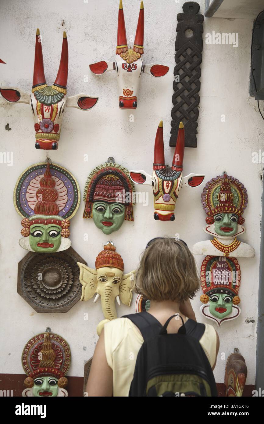 Tourist looking various types of masks displayed on wall kept for sell ...