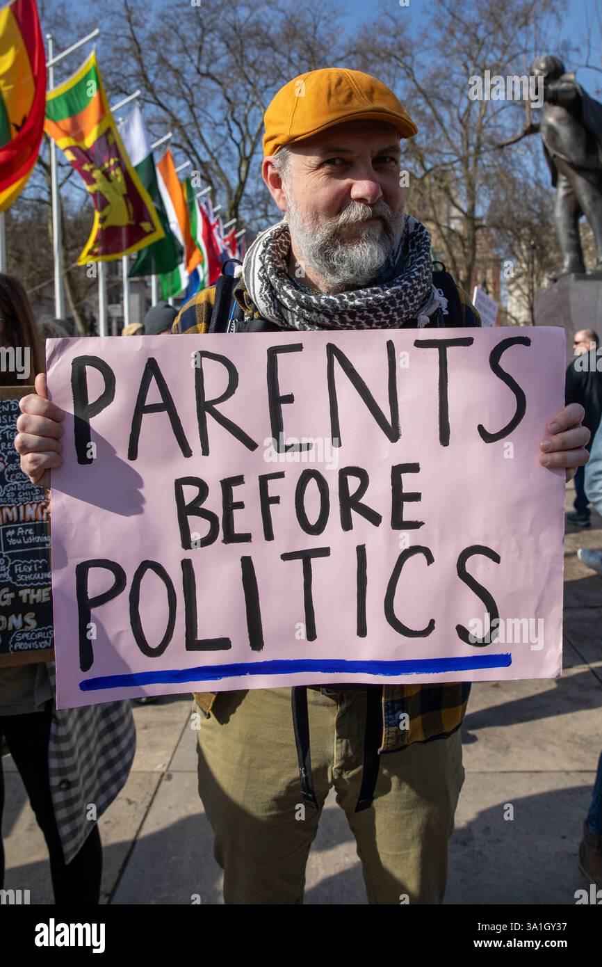 A demonstrator holds a placard during the rally. Parents, home ...