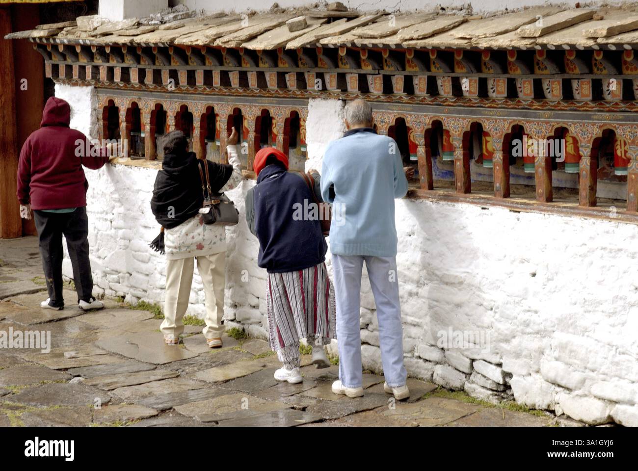 Tourist swinging Chinese holy bells at Kaichu Chorten Paro Royal Govt ...