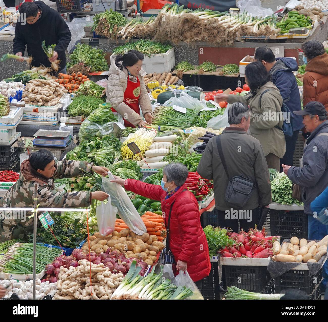 YANTAI, CHINA - MARCH 9, 2025 - Consumers buy vegetables at a farmer's ...
