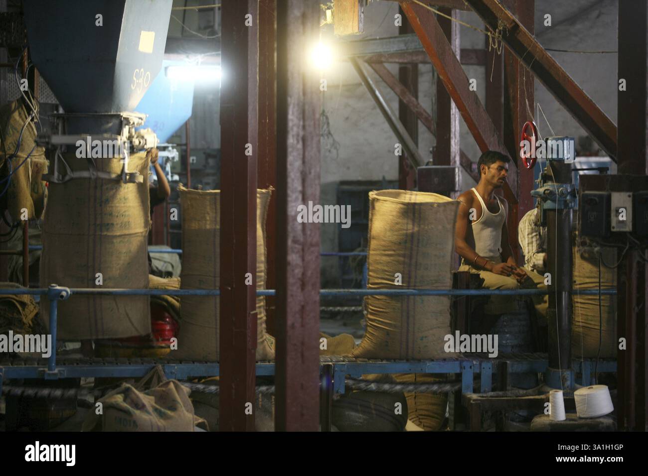 Workers filling sugar in the jute bag at the sugar factory in Sangli ...