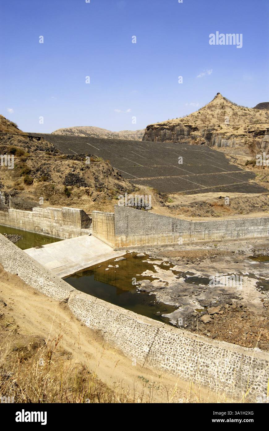 Earthen dam with stone pitching constructed between rock mountains at ...