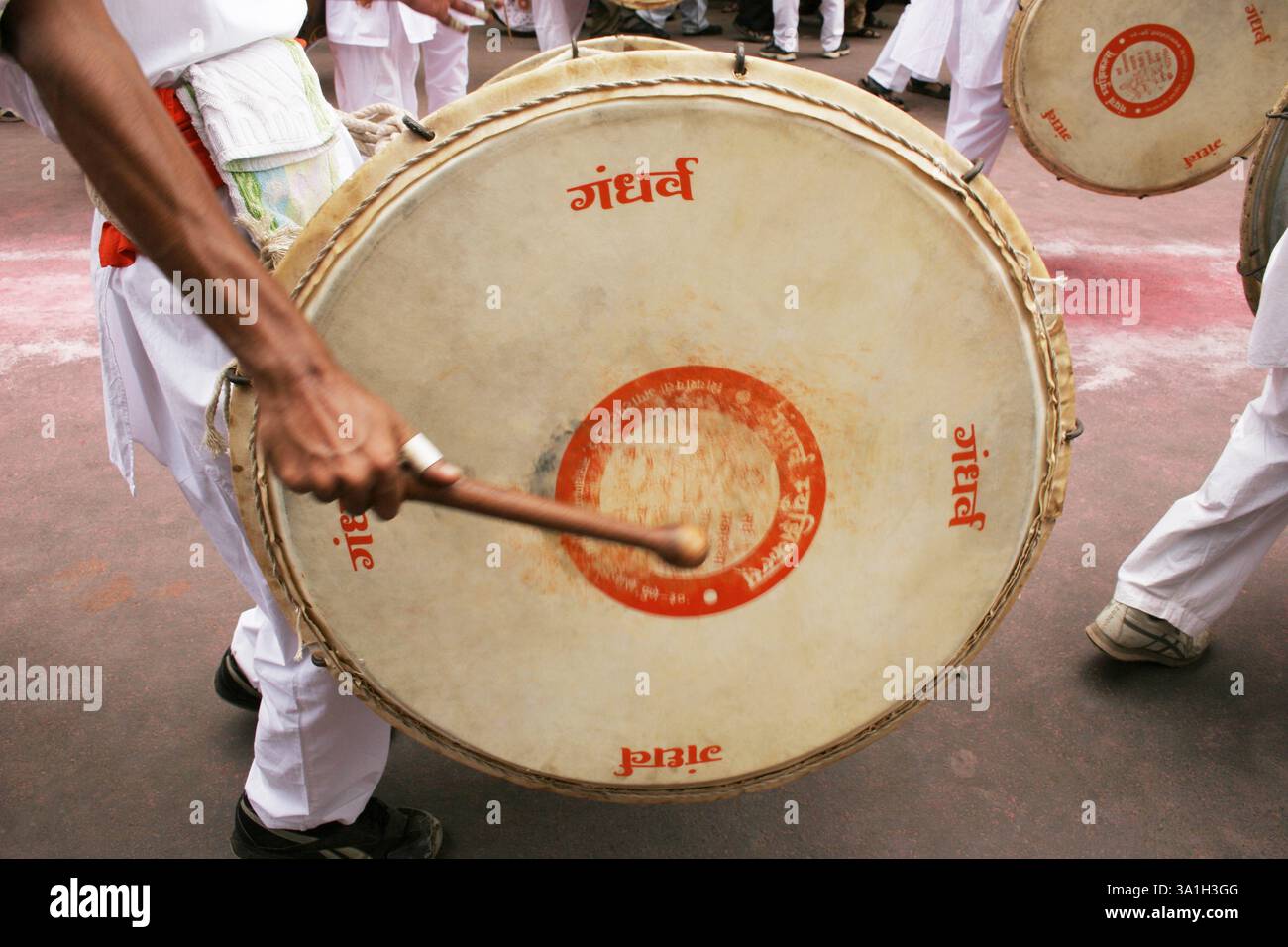 Man playing musical instrument dhol during immersion of Lord Ganesh ...
