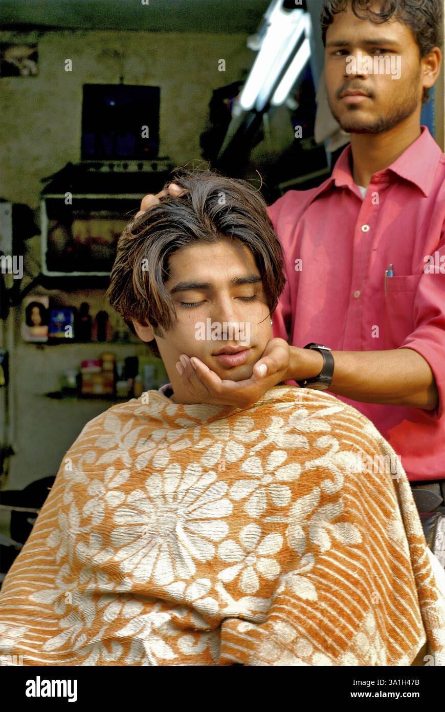 A Young man getting his head massage done at Taj hair and beauty saloon ...