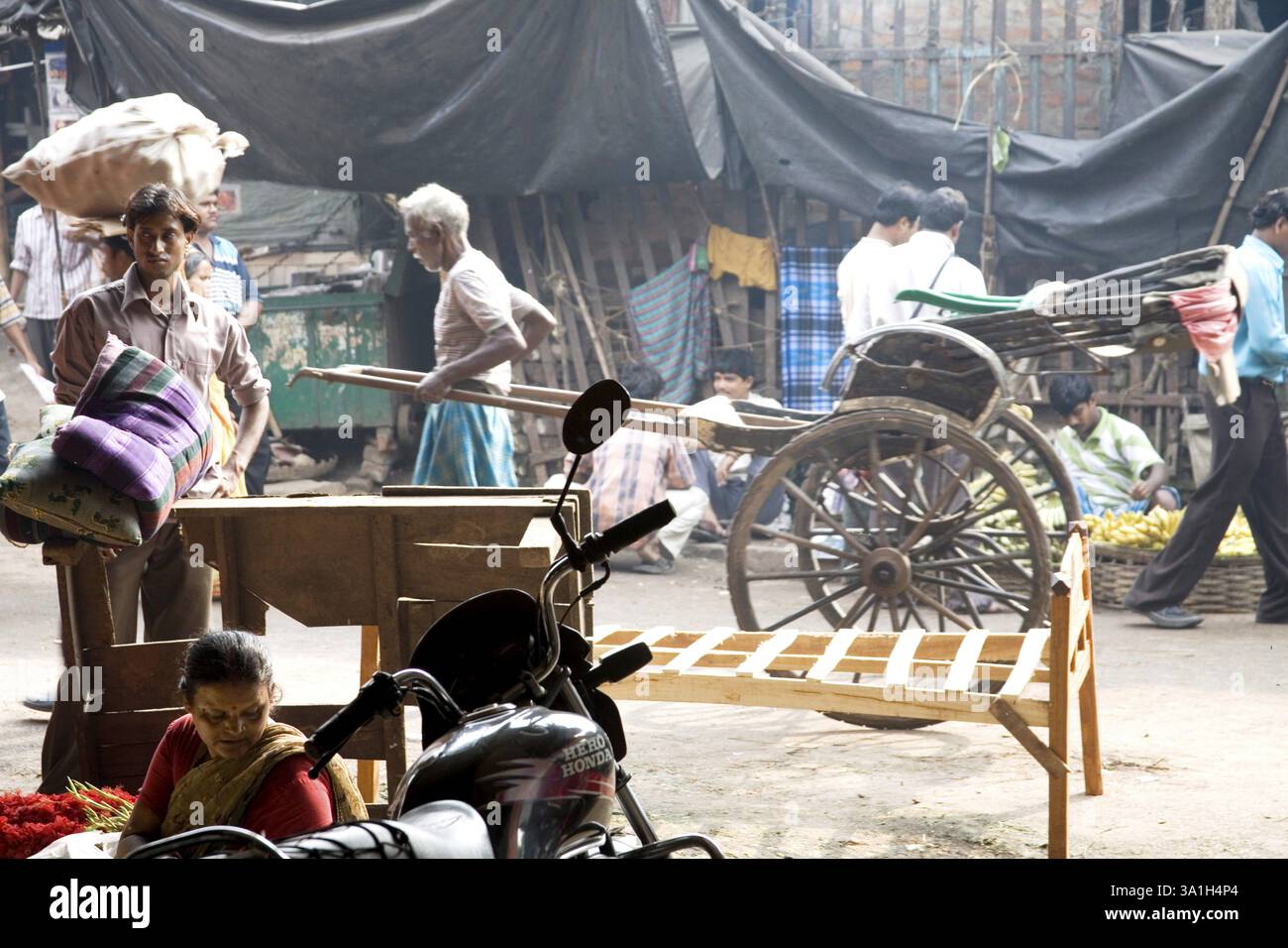 Street scene, old man pulling hand rickshaw in busy lane, Siyaldah ...