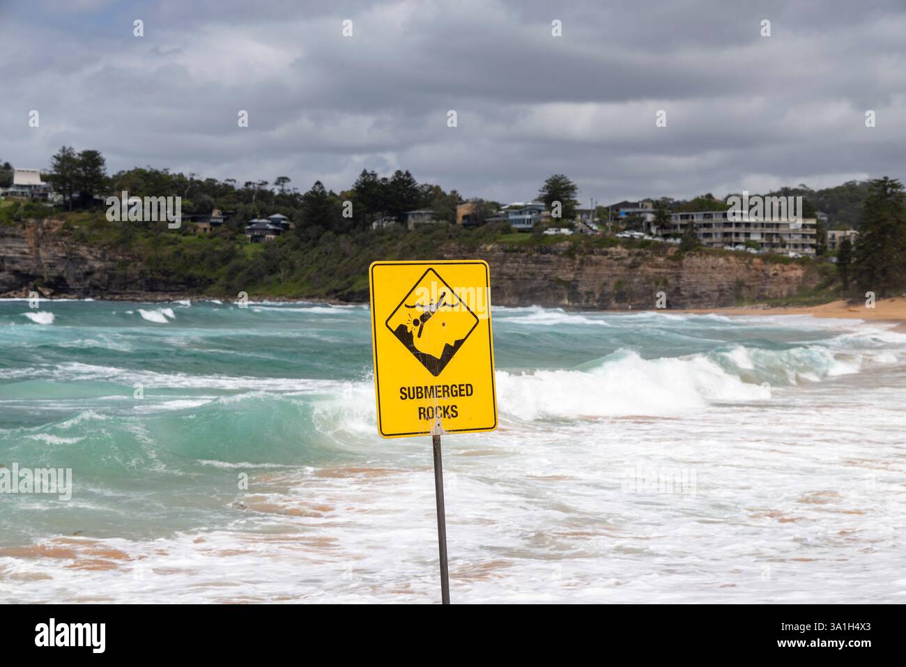 Danger submerged rocks sign on Avalon Beach in Sydney, warning swimmers ...