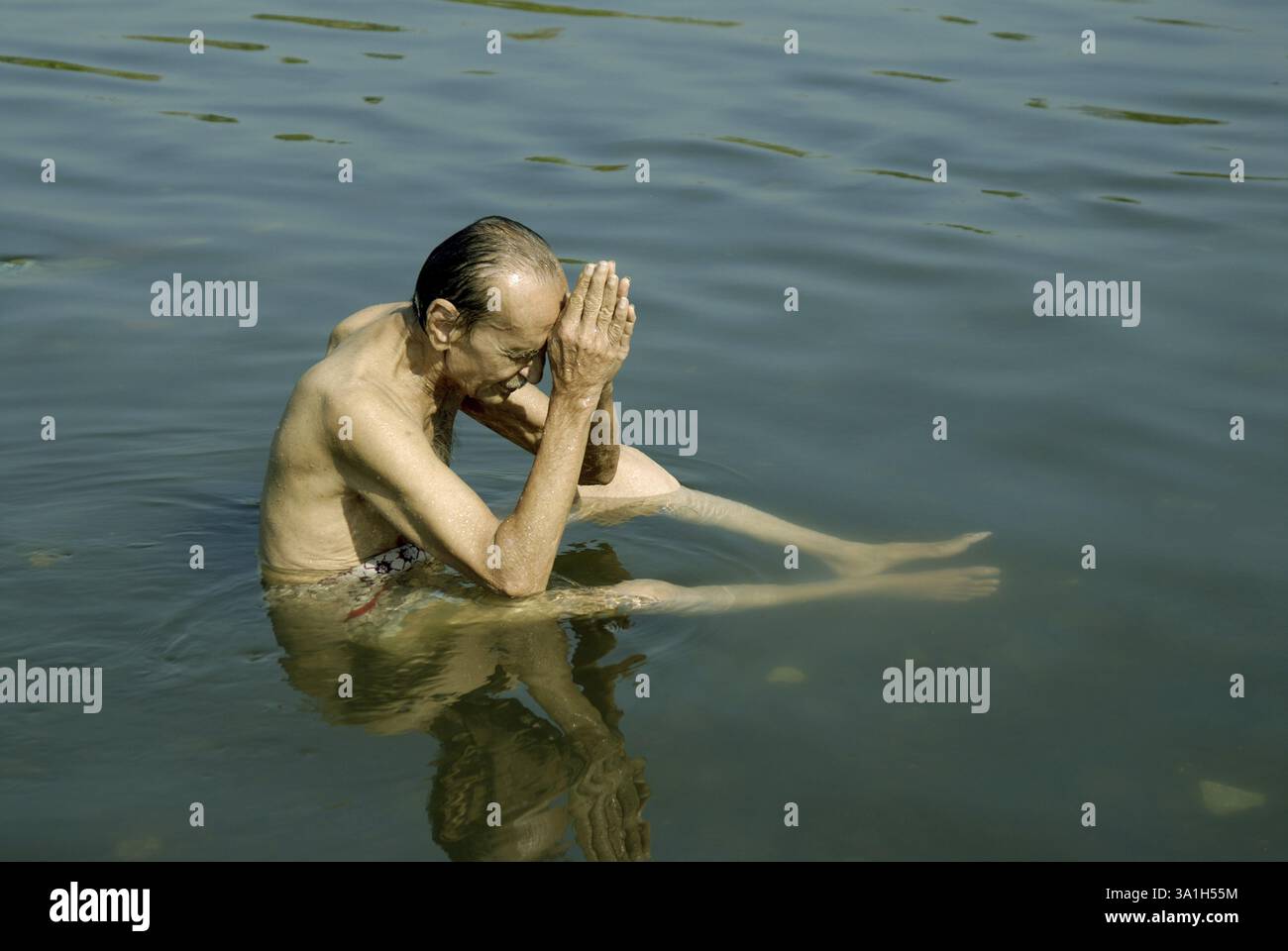 Old man praying to sun sitting in Tansa River at Vajreshwari Thane ...