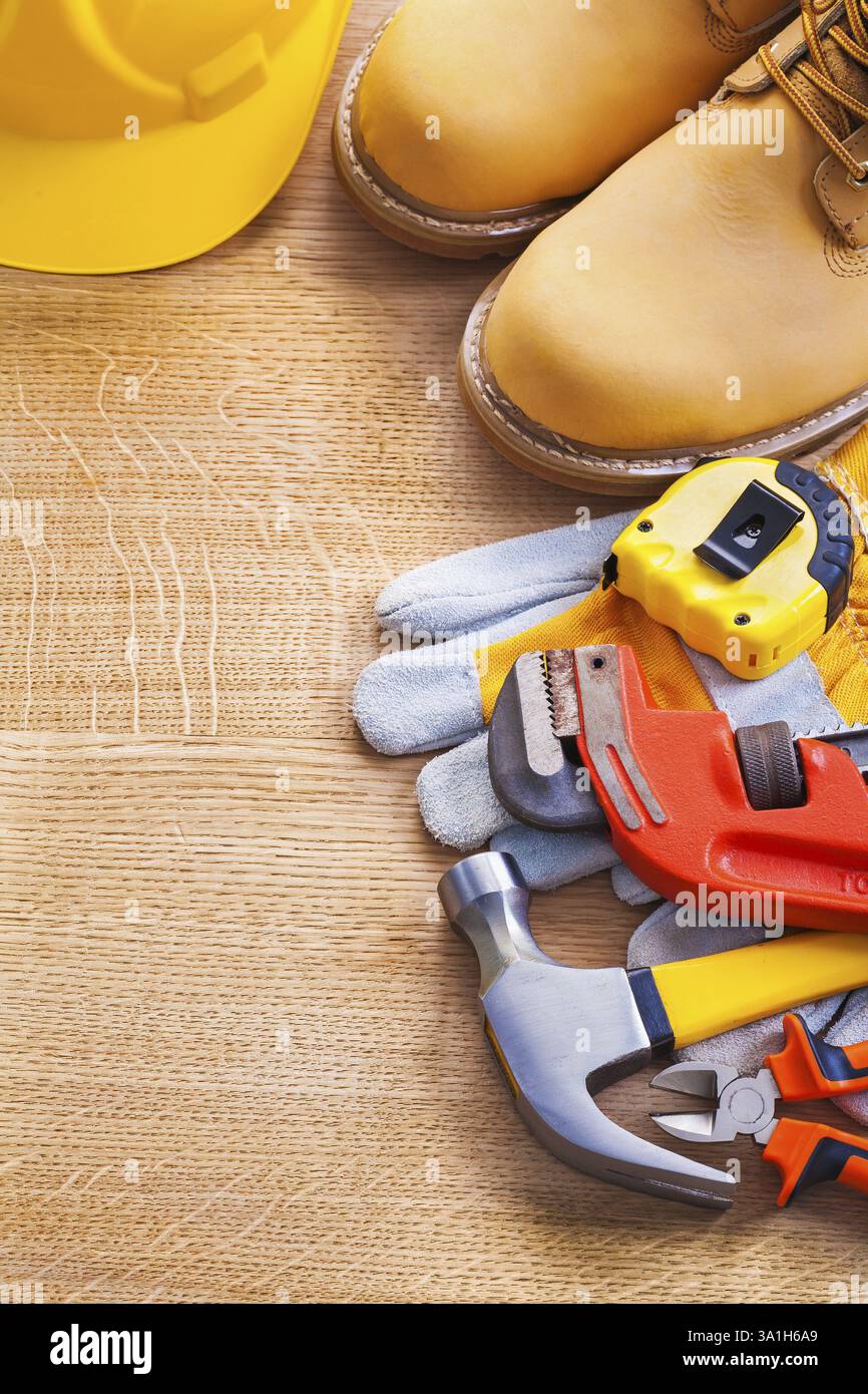 Helmet boots glove tapeline monkey wrench hammer nippers on wooden ...