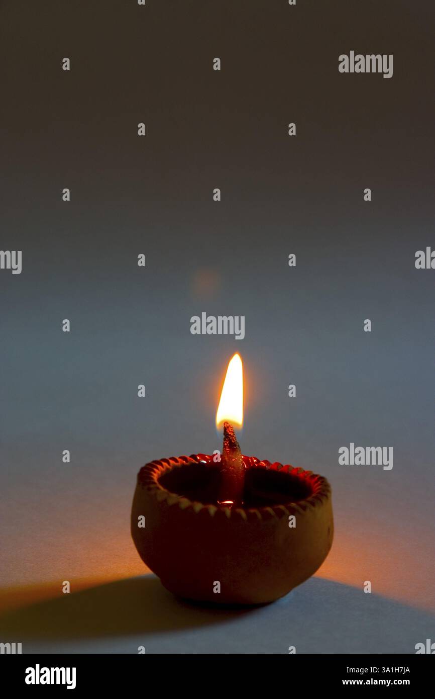 One diya clay oil lamp a source of light as flame on white background ...