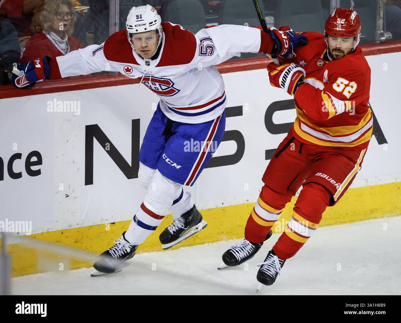 Montreal Canadiens' Emil Heineman, left, is checked by Calgary Flames ...