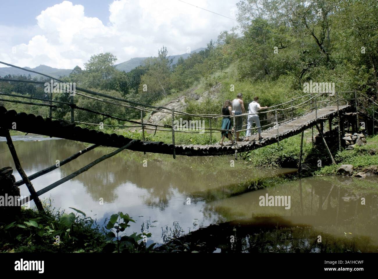 Tourists crossing bridge over river in Elephant valley, Kodiakanal ...