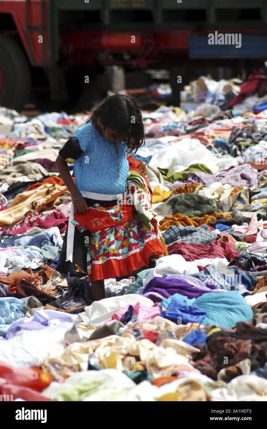 A girl selecting clothes from the stacks of clothes that arrived ...
