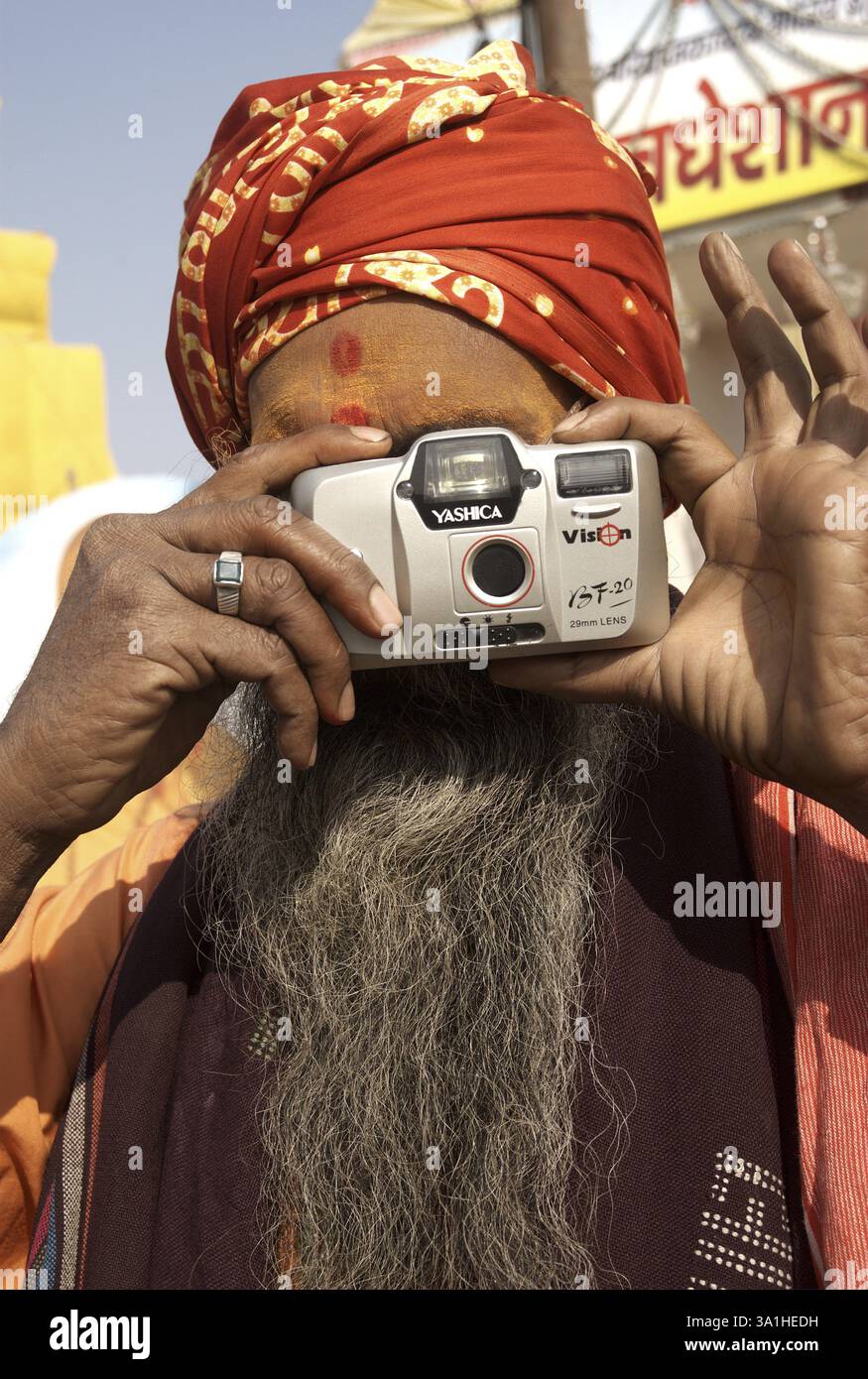 A saint, sadhu takes photographs of his fellow sadhus with a film ...