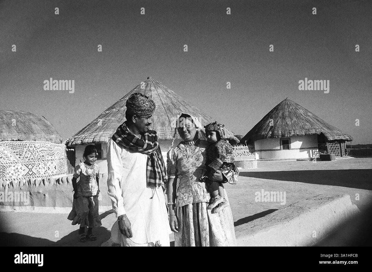 Villagers family and traditional huts in background, Hudko, Kutch ...