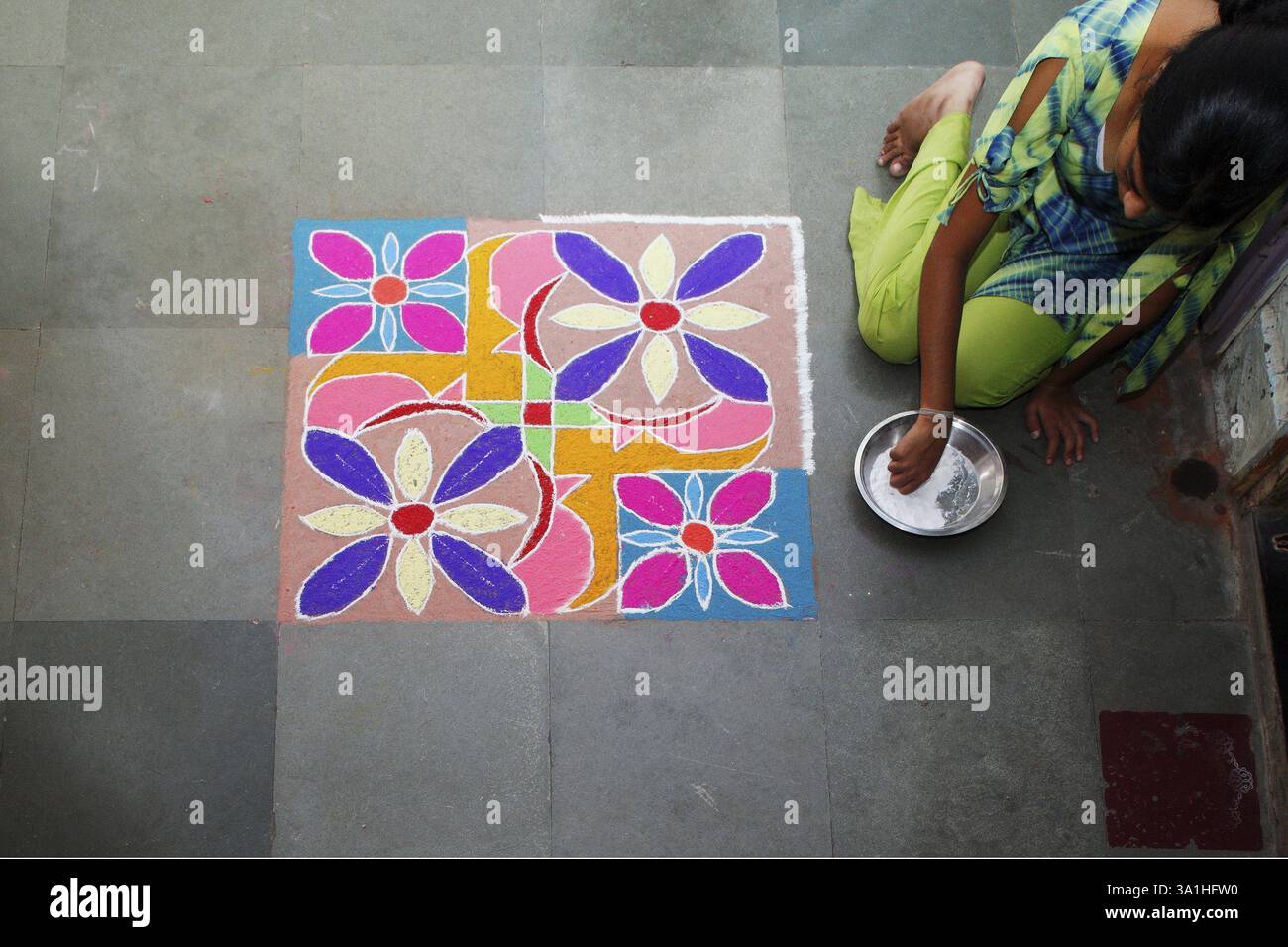 Girl filling white color on border of rangoli design on Diwali ...