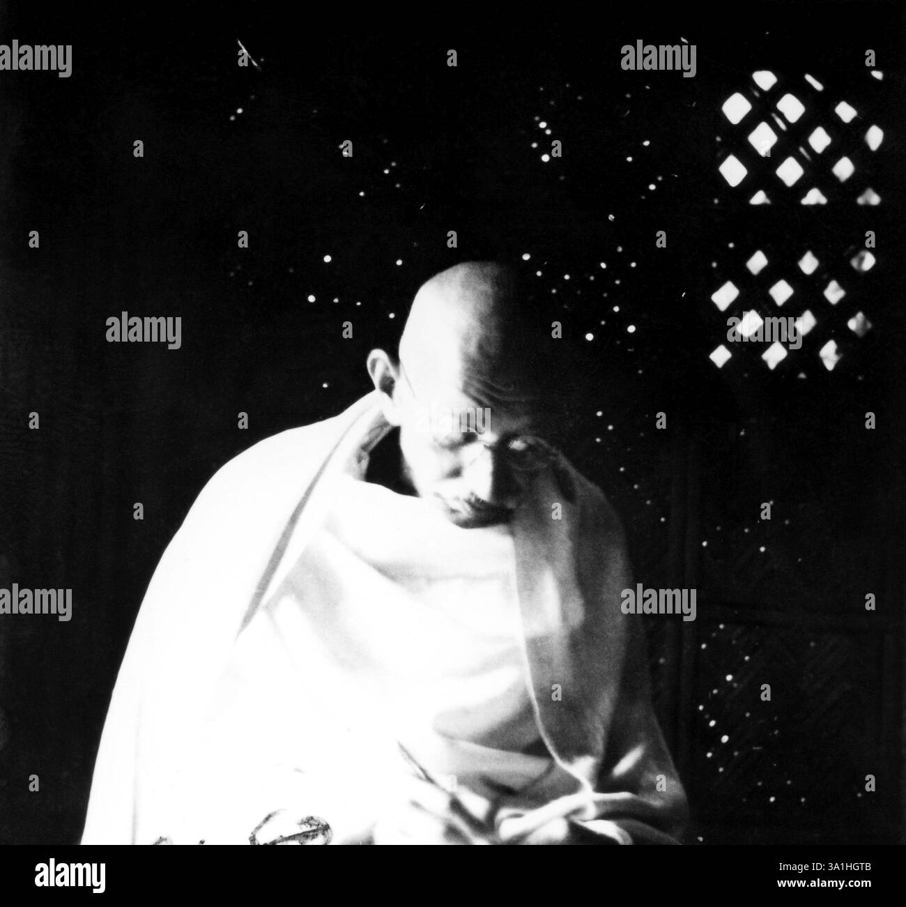 Mahatma Gandhi, sitting in a hut and writing during his visit of the ...