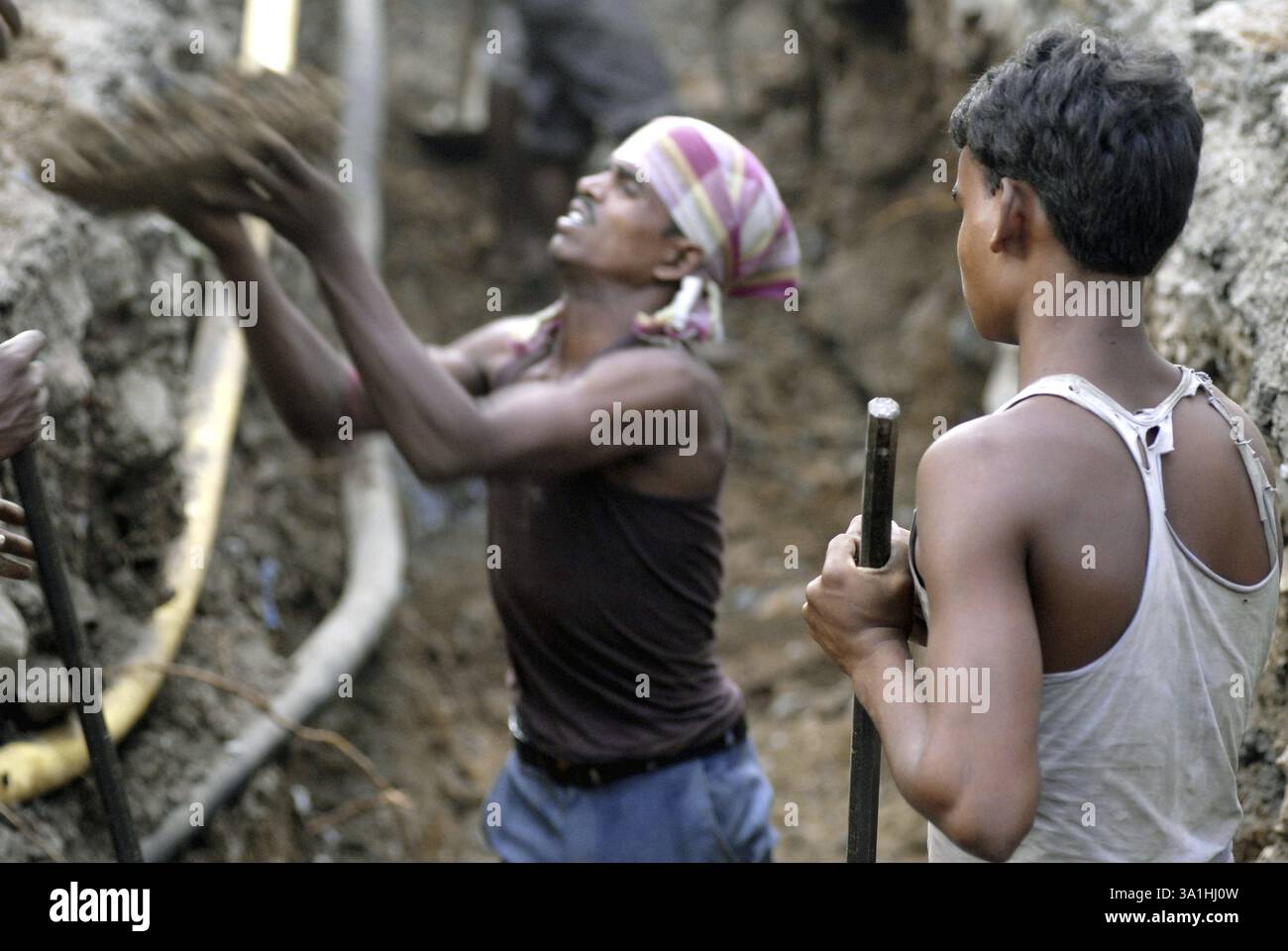 Road construction workers dig the road to lay an underground drainage ...
