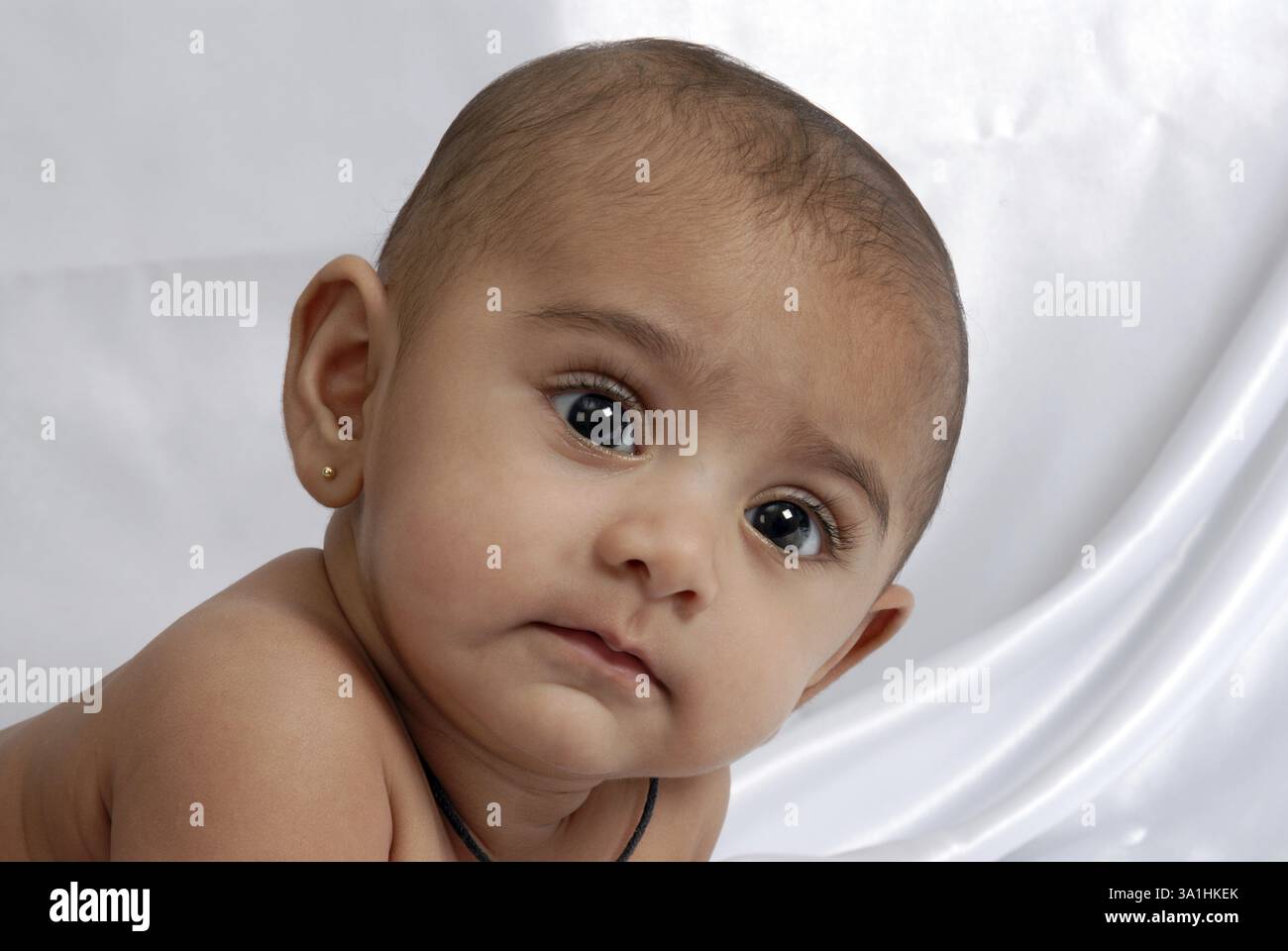 South Asian Indian baby, naughty expression, looking at side, white ...