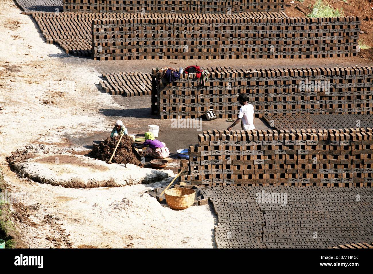 A worker handing over a brick at the brick factory in a village of ...