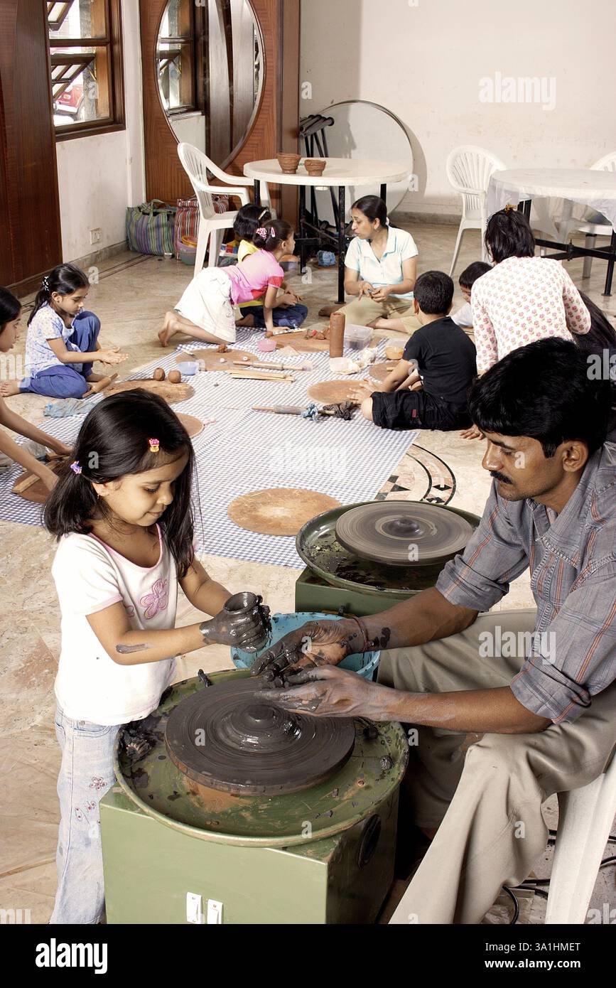 Pottery class for children, potter teaching children how to make pot on wheel with other ...