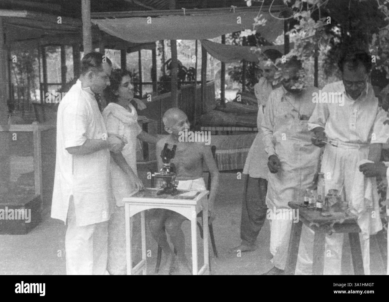 Mahatma Gandhi observing a hookworm cell through a microscope ...