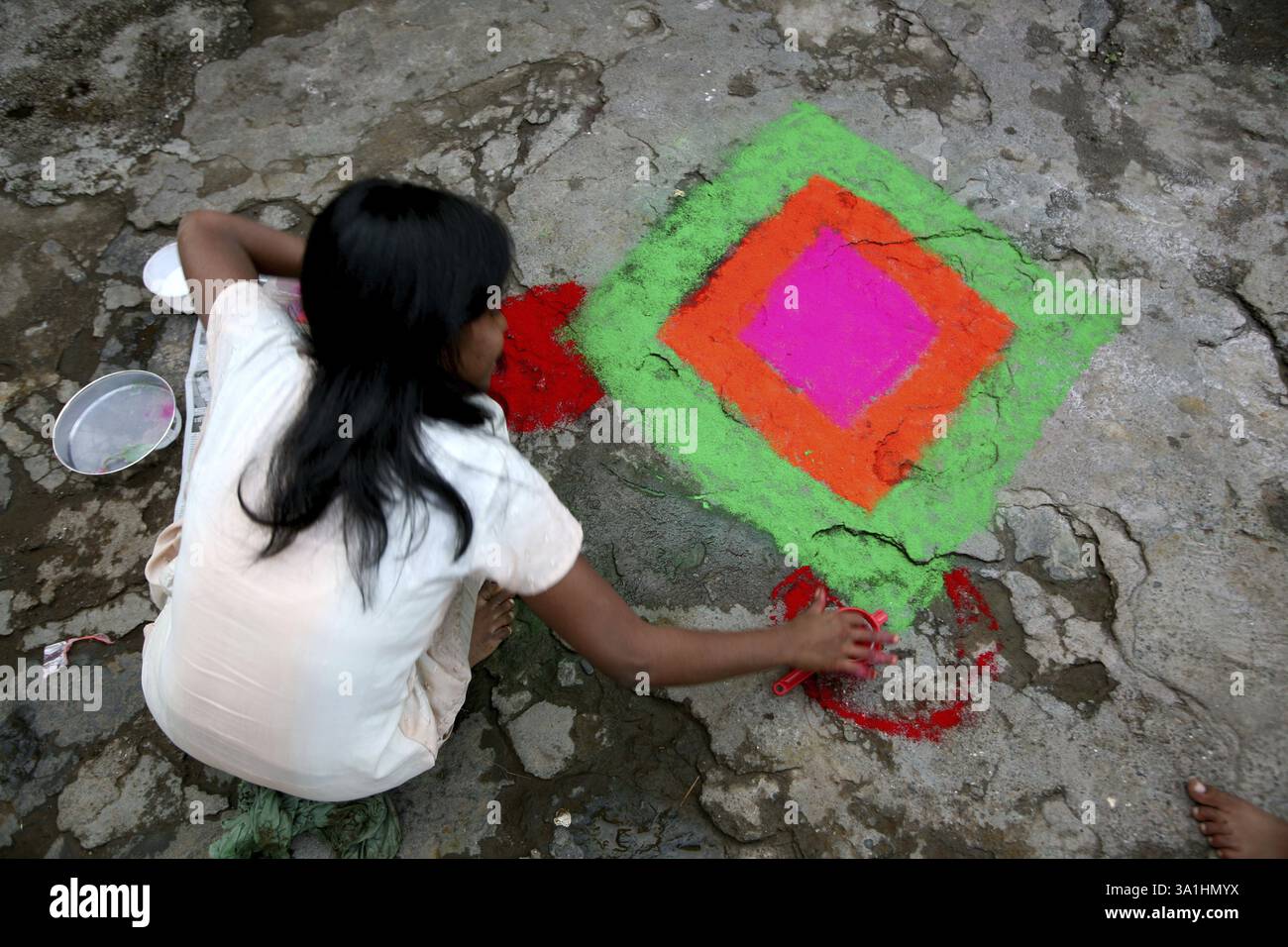 A girl making a colourful rangoli at the famous Jejuri temple, pune ...