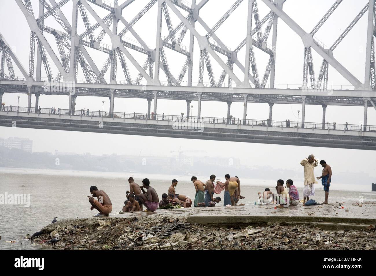 Activities on Babu ghat, Howrah bridge over Hooghly river in background ...