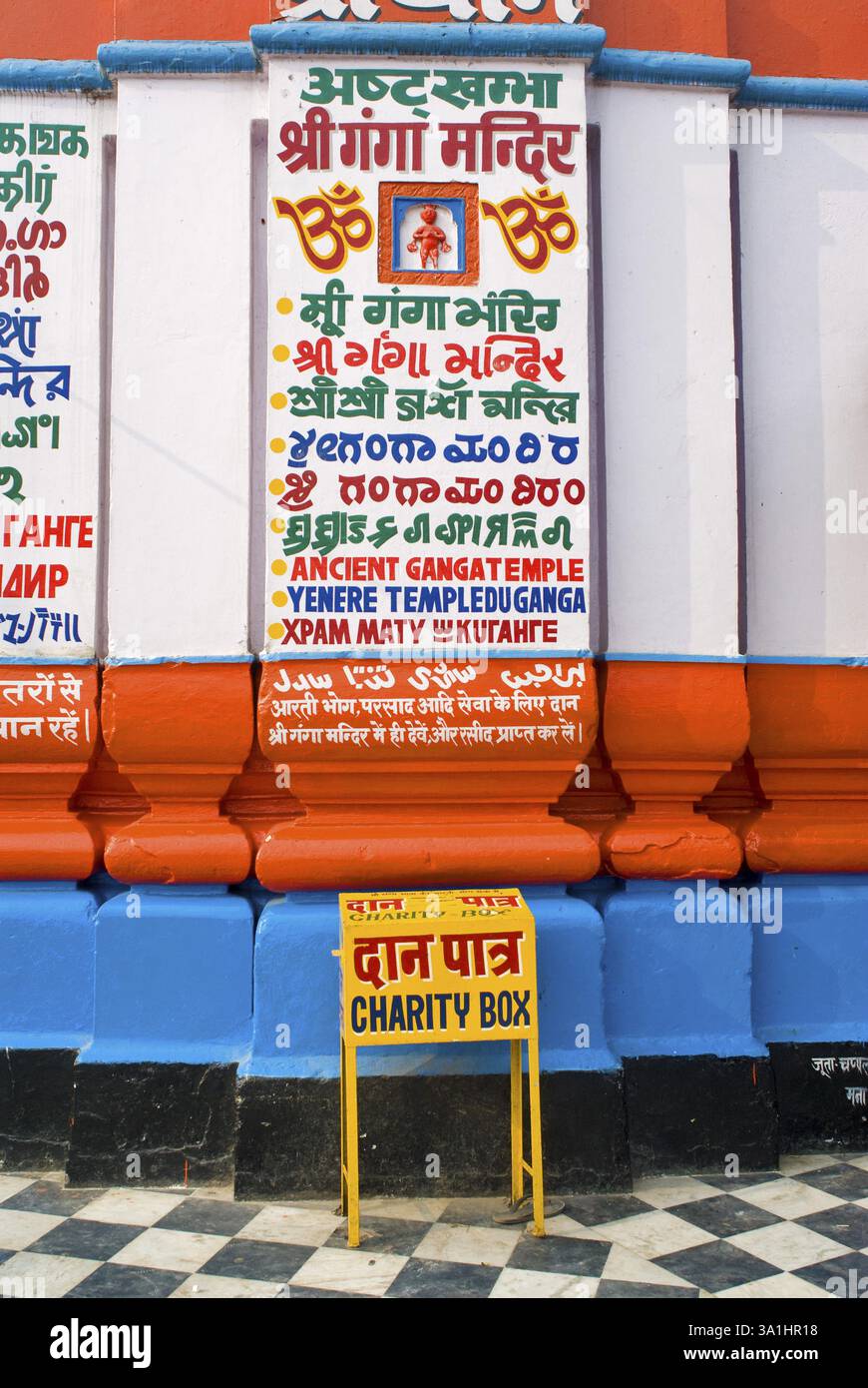 Yellow charity box of ancient Ganga temple on banks of river Ganga ...