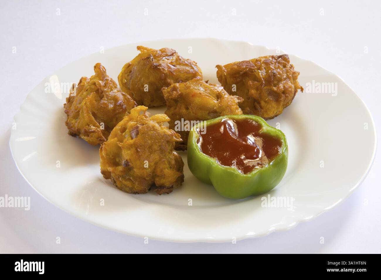 Indian fast food fried kanda bhaji served with tomato ketchup in plate ...