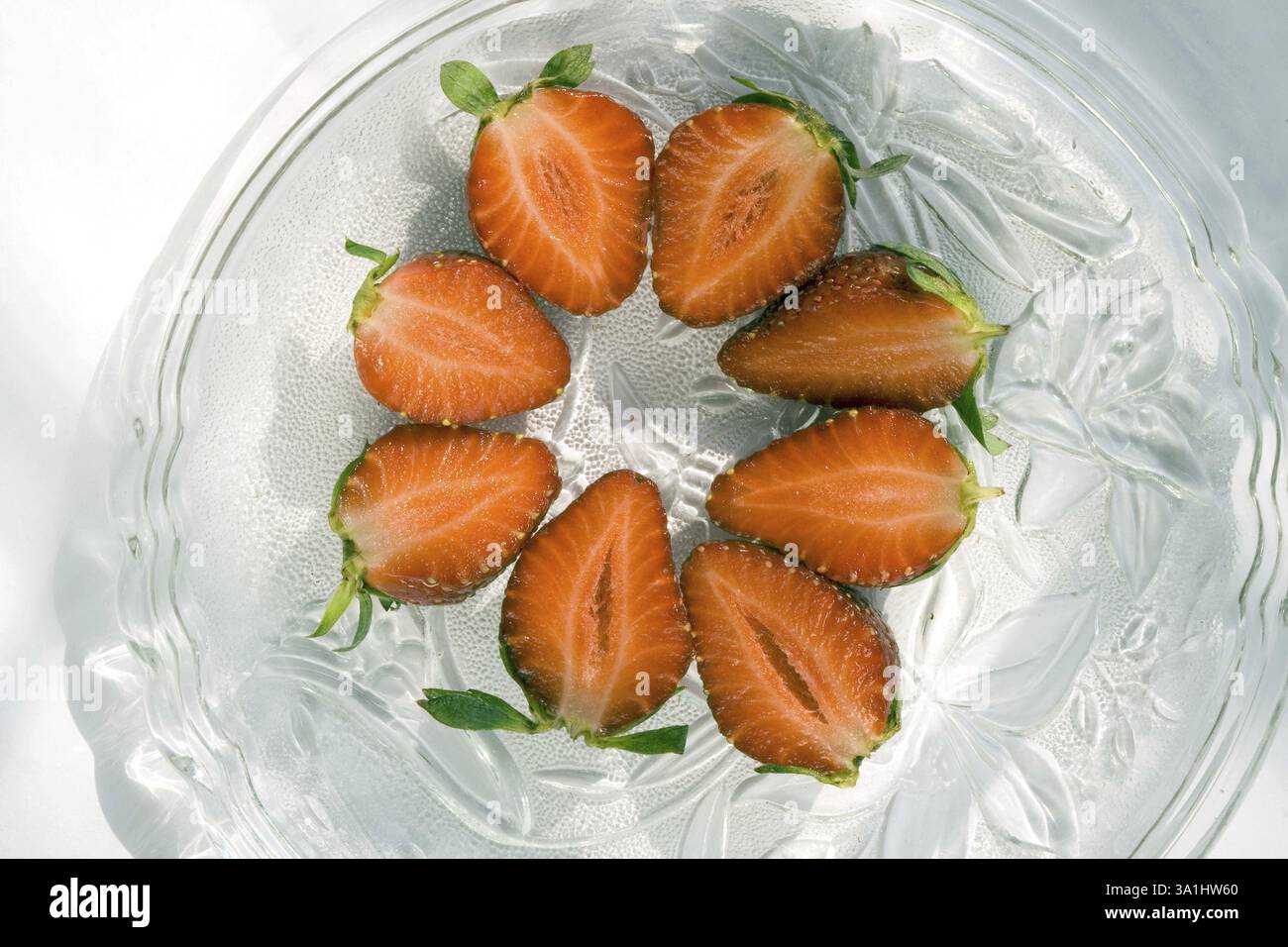 Half cut strawberry in bowls on white background Stock Photo - Alamy