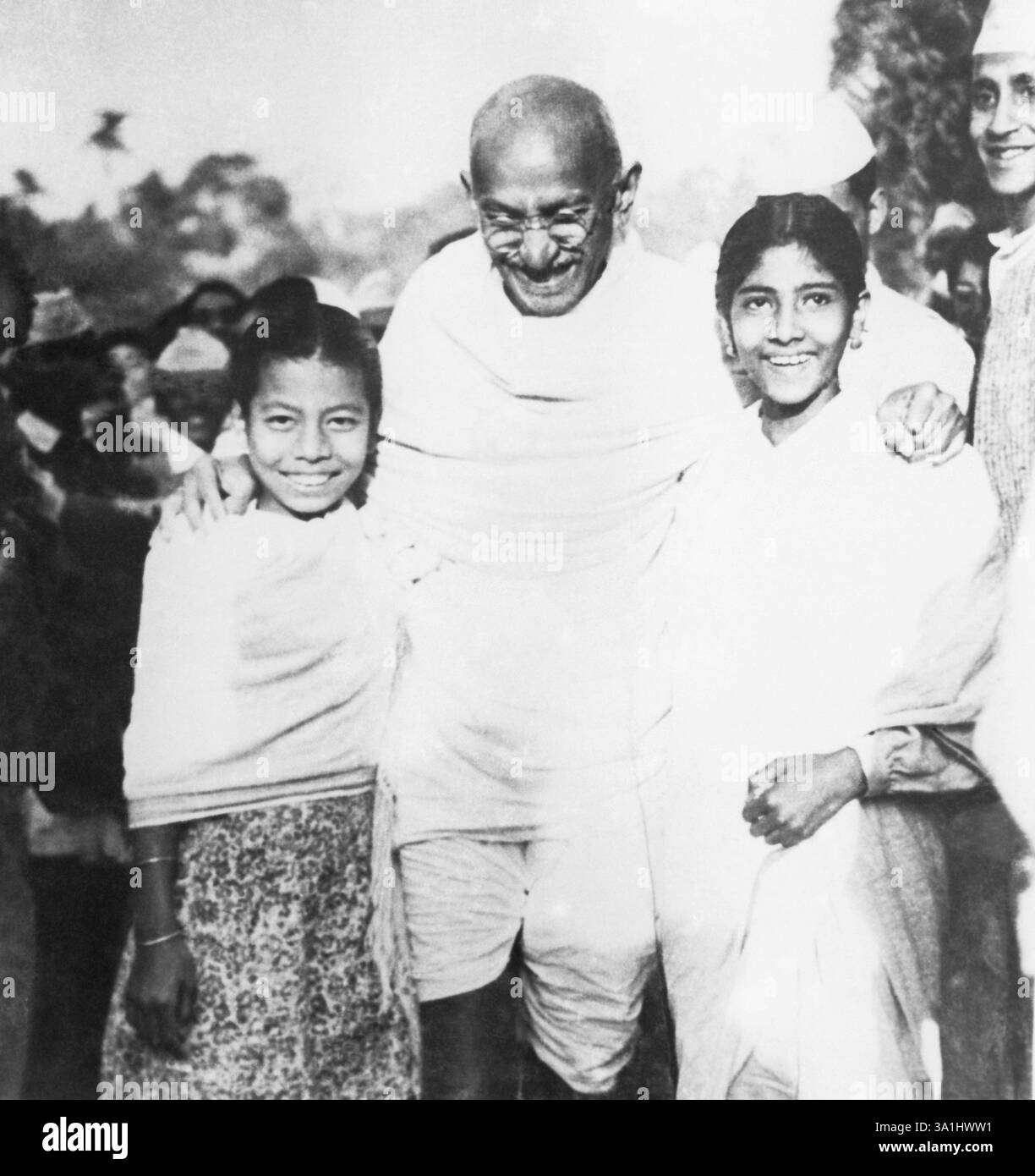 Mahatma Gandhi, supported by two girls, sharing a laugh with them, 1945 ...