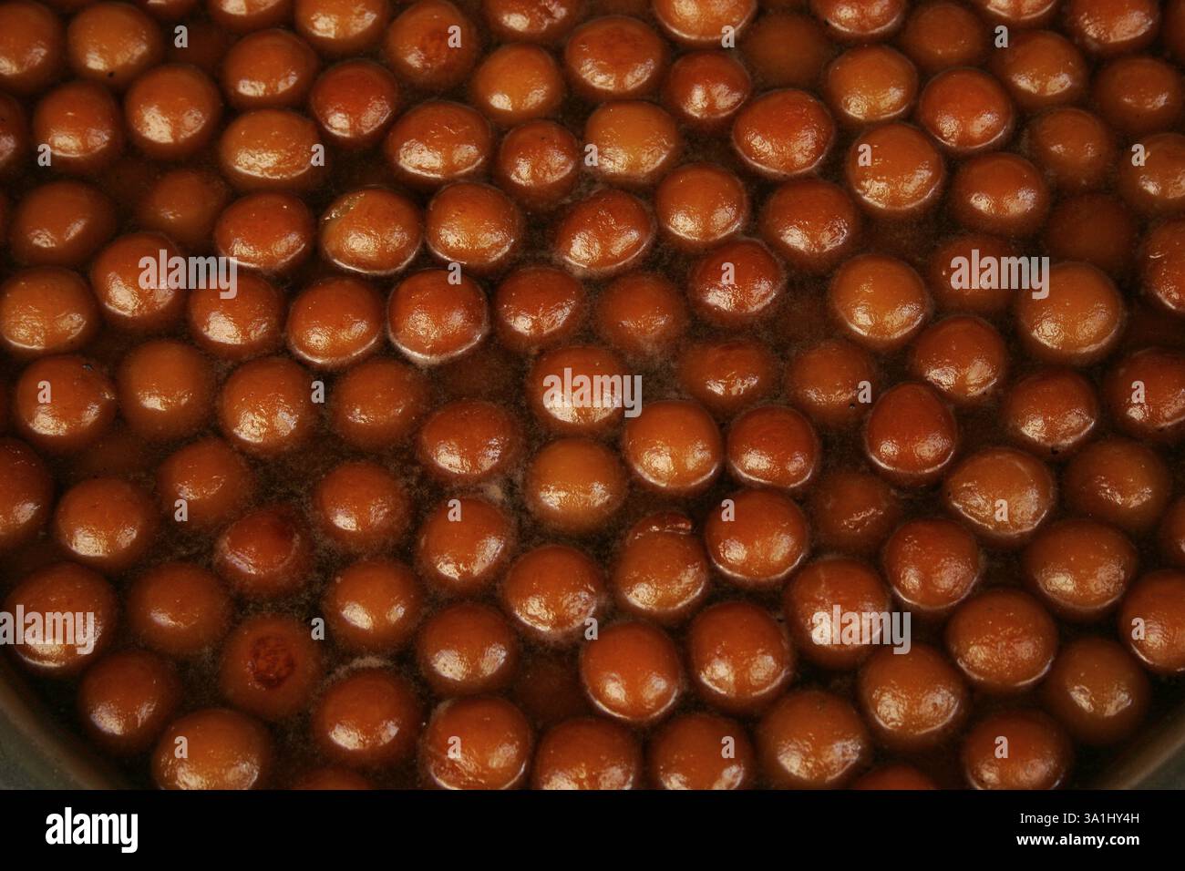 Indian sweet mithai called Gulab Jamun floating in sugar syrup ...
