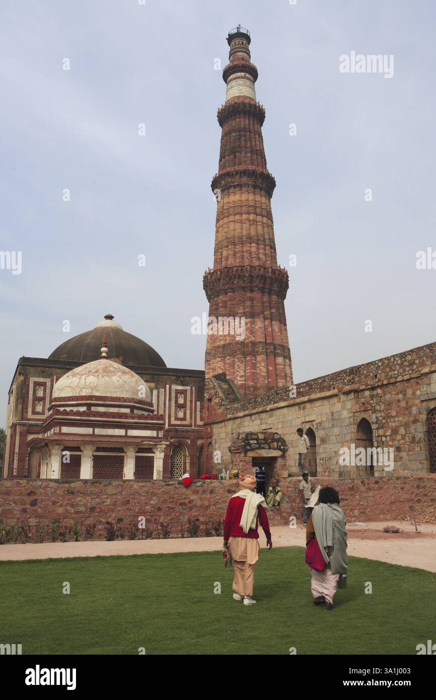 Indian sadhu watching Qutb Minar built in 1311 red sandstone tower ...