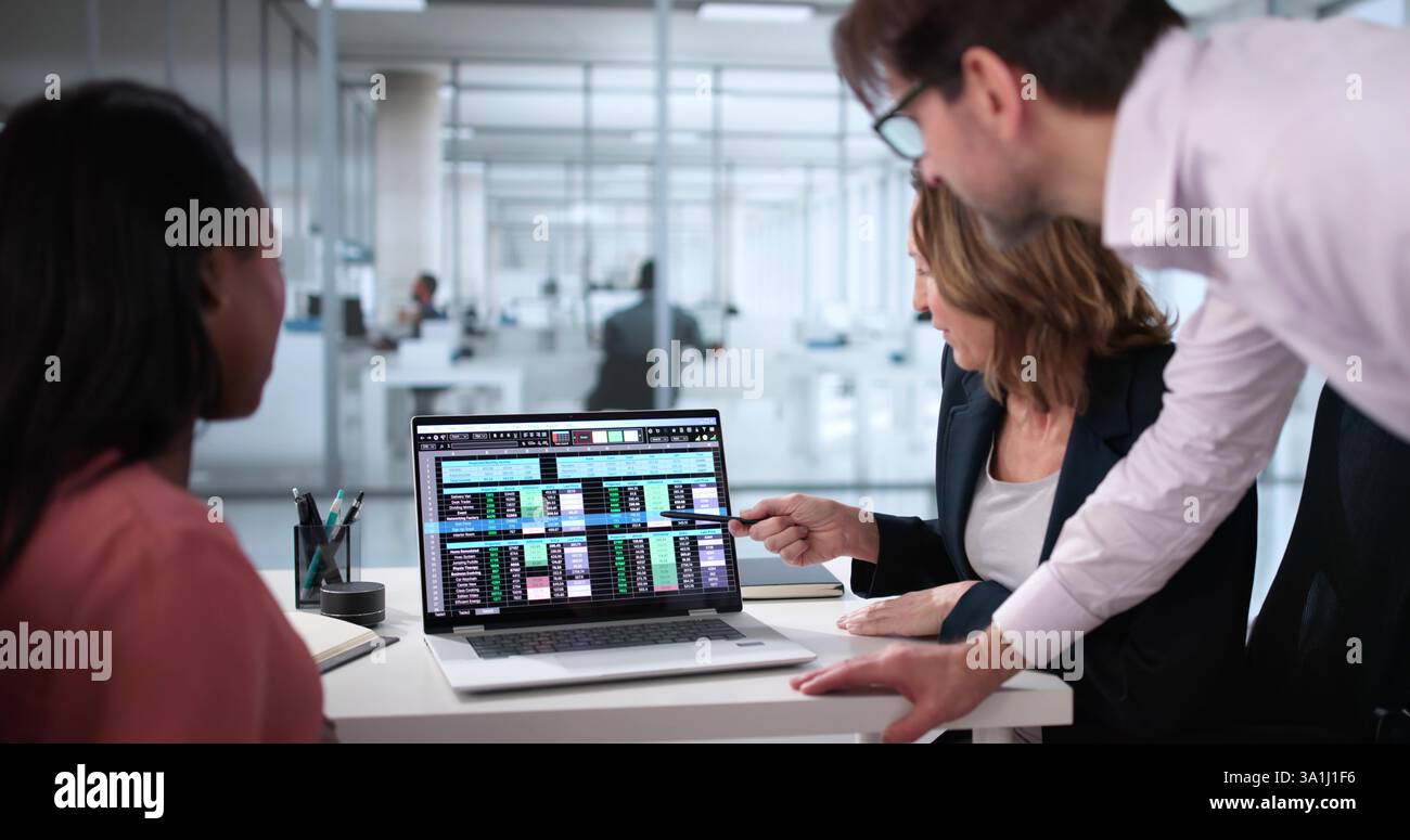 Busy Business Professionals Collaborating on Spreadsheet Report Using ...