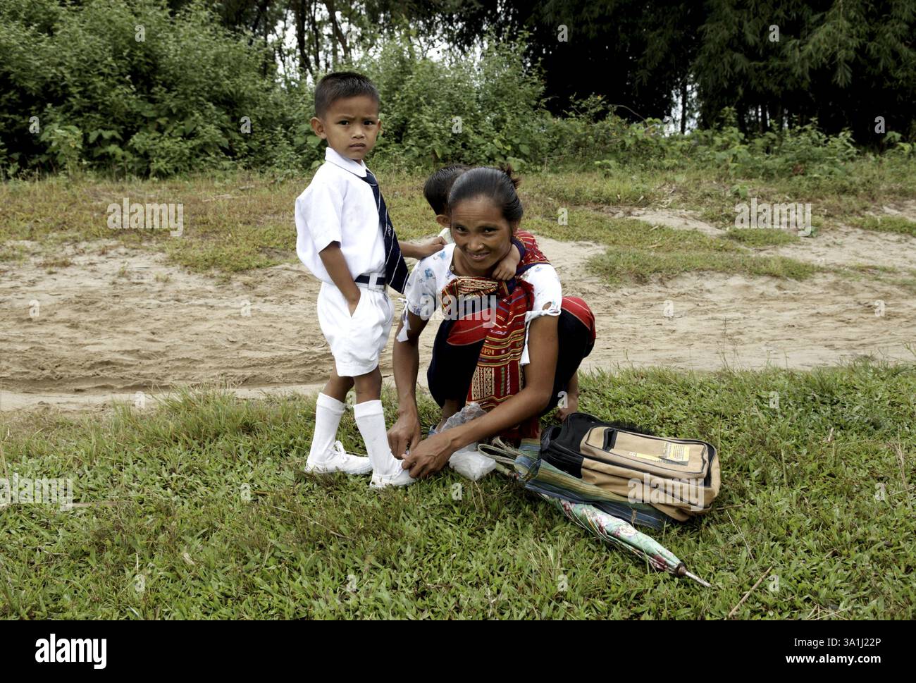 Chakma tribal women preparing her son for school, Diyun, Arunachal ...