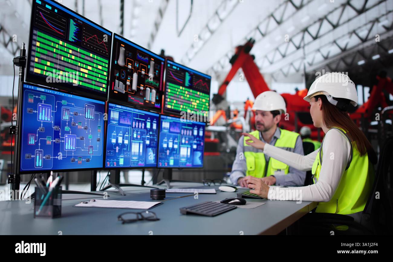 Man and woman monitor vehicle production on computer in factory Stock ...