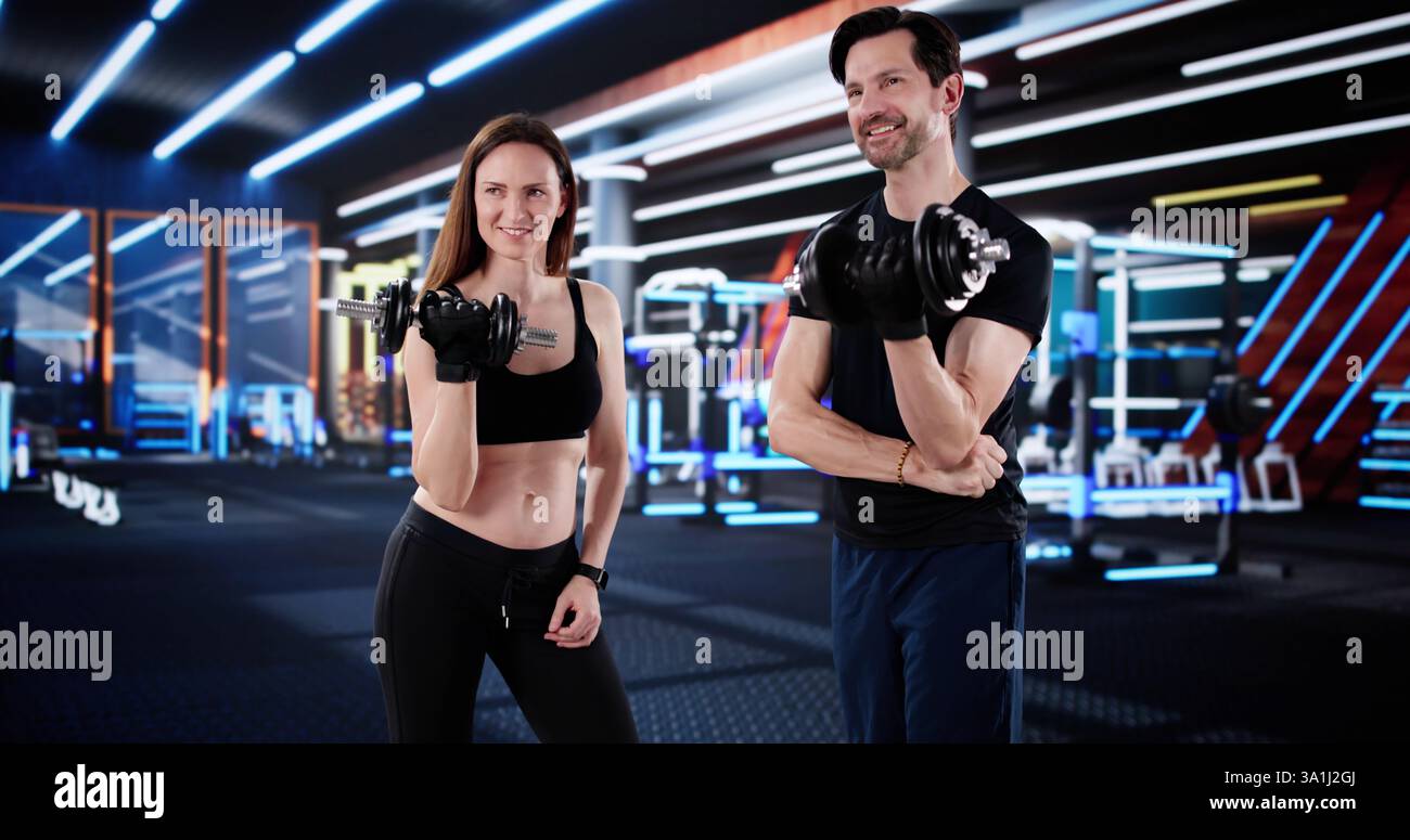 Personal Trainer Helps Mature Couple with Weightlifting in Gym Stock ...