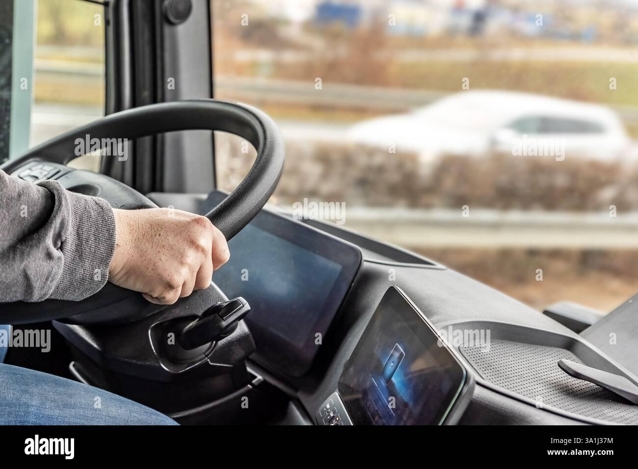 Driving modern truck concept. Side view of driver in interior of truck ...