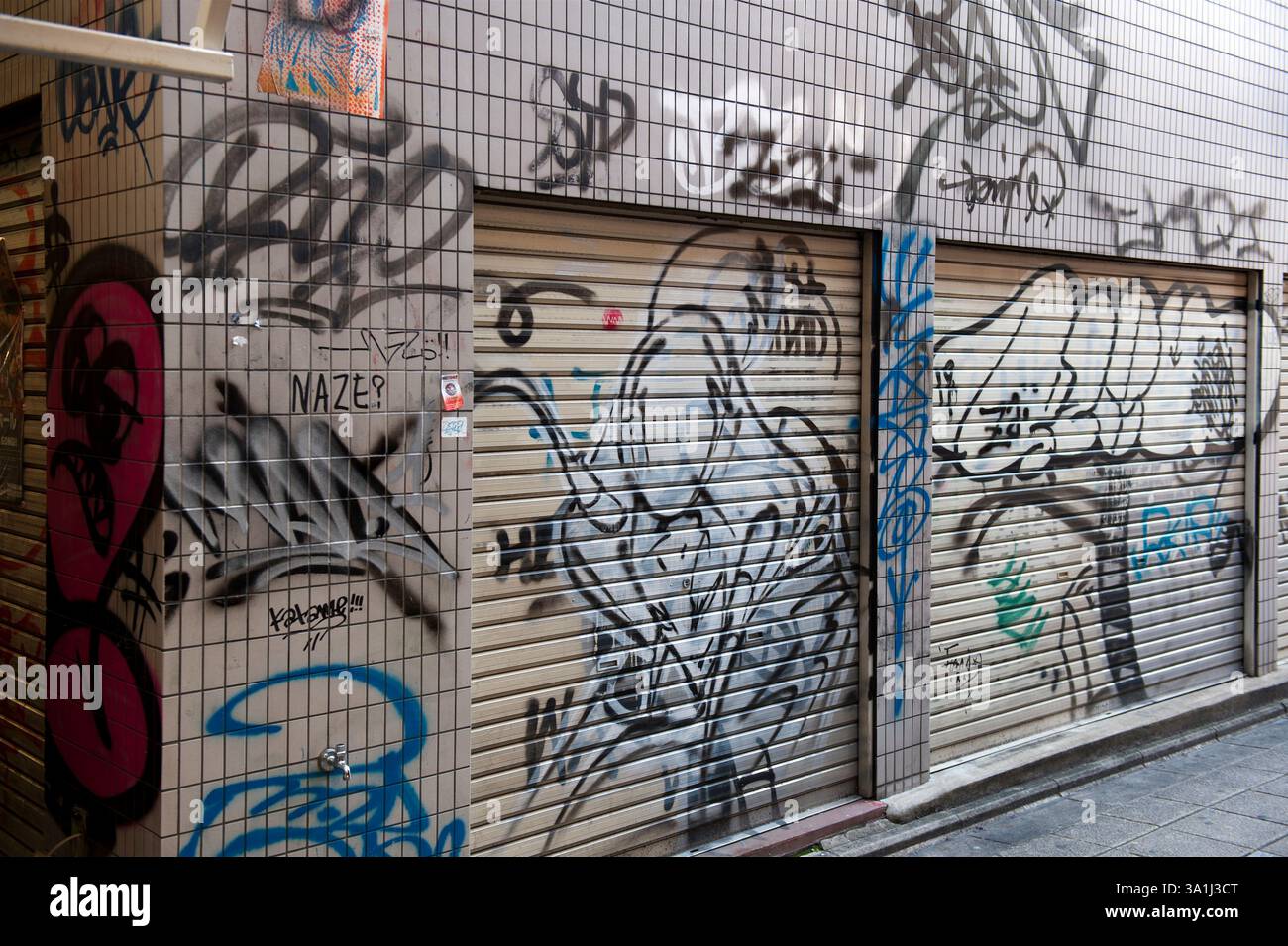 Graffiti (rakugaki, in Japanese) sprayed on building facade in downtown ...