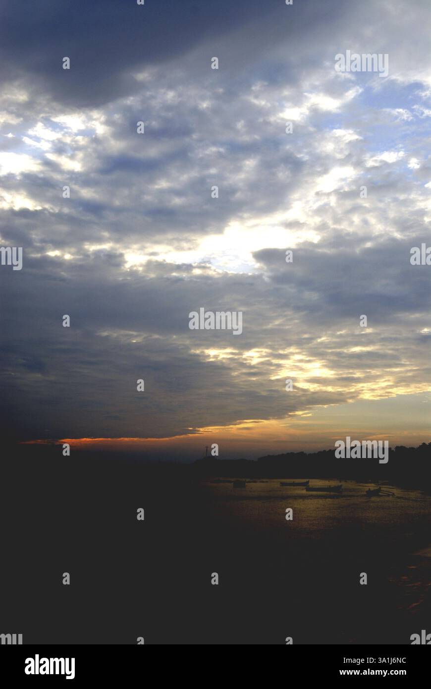 Colorful cloudy sunset with small country fishing boats at Malvan beach ...