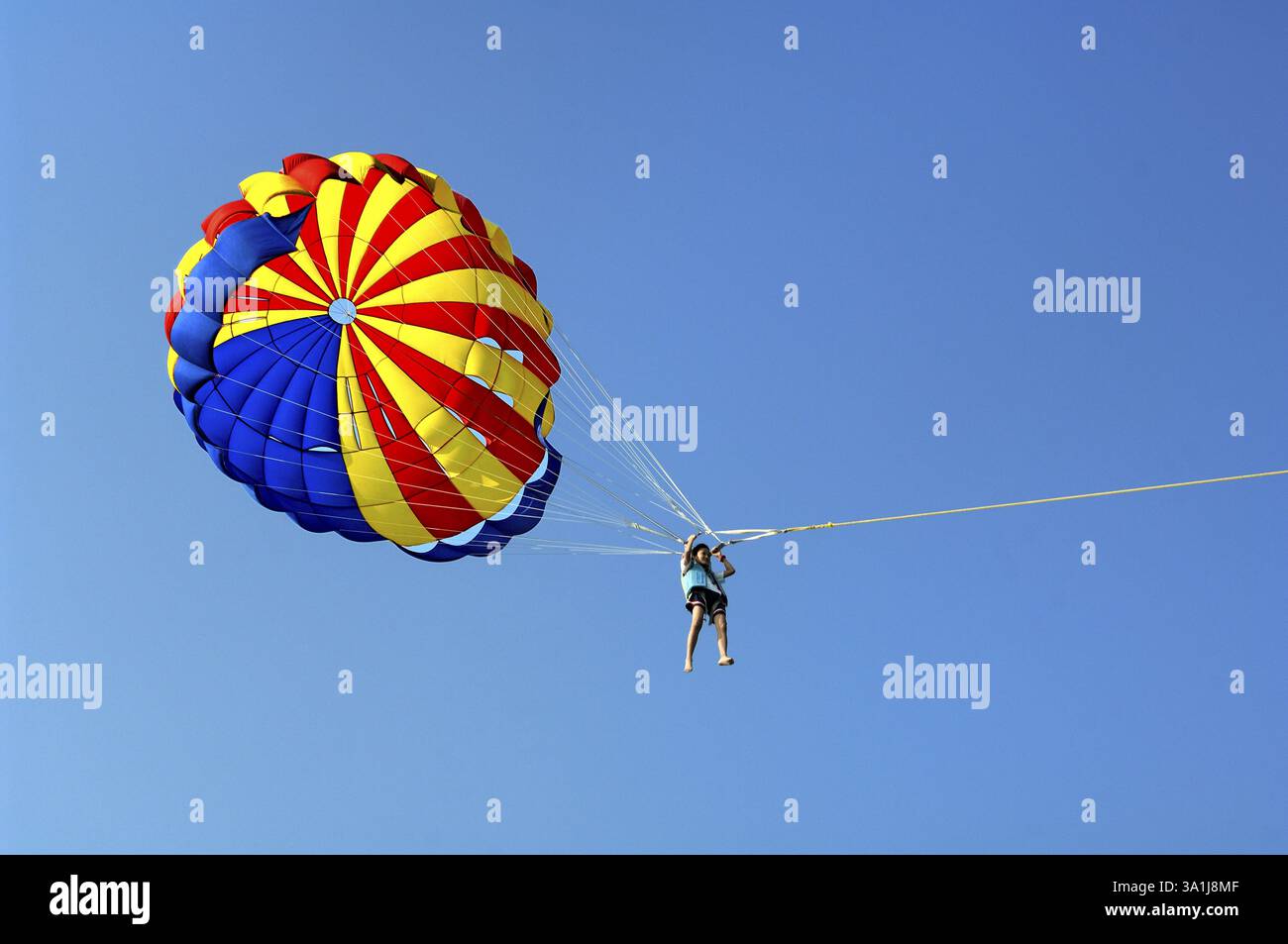 Tricolour Parasail against blue sky Parasailing water sports ...
