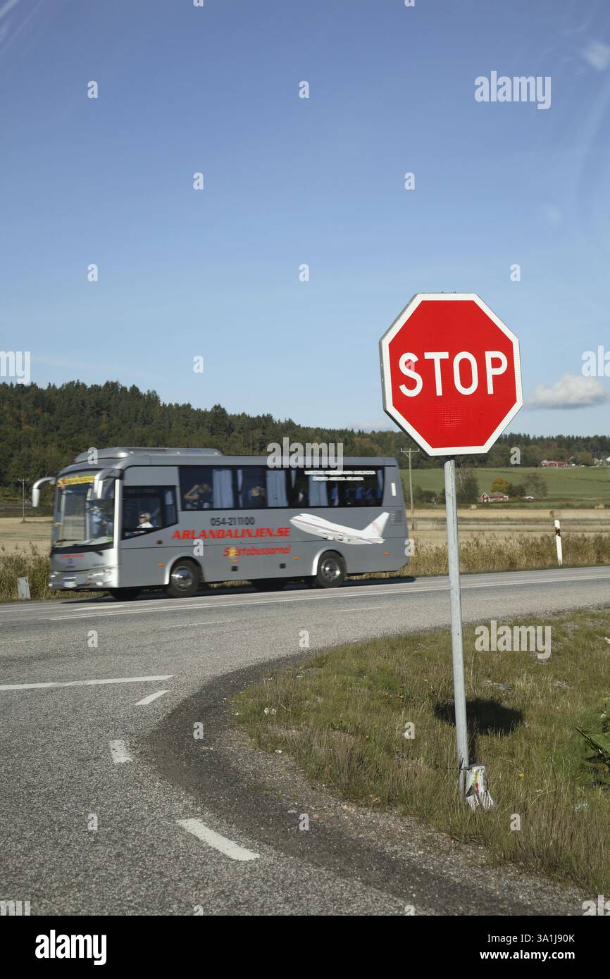 White and red sign board showing stop in bold letters and bus in ...
