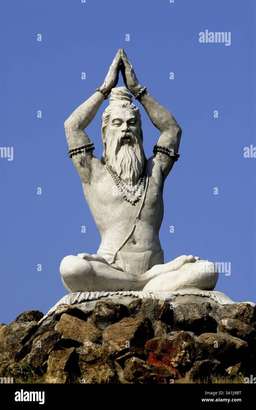 Statue of Holy man in Padmasana worshiping God on small hillock of ...