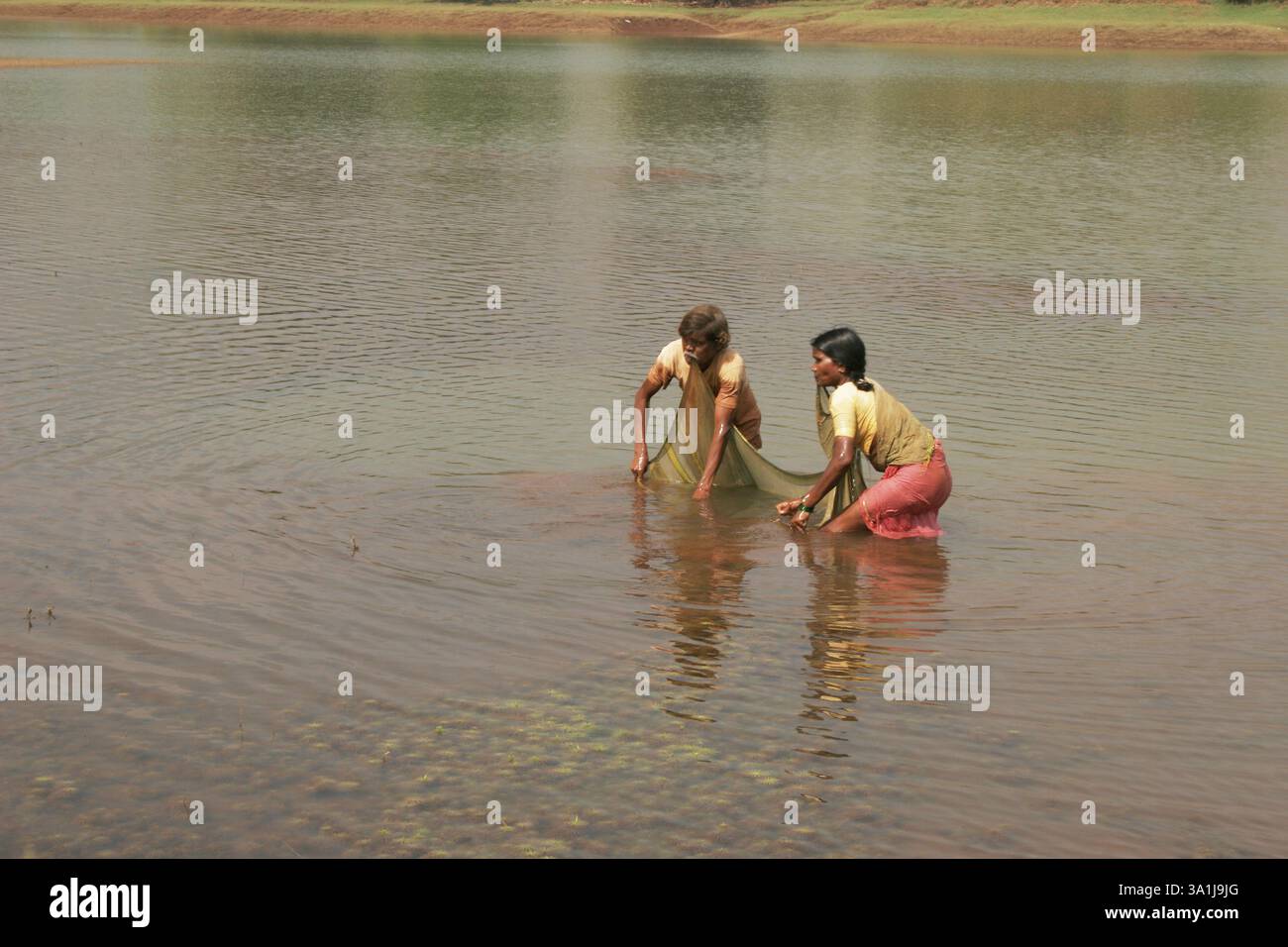 Maharashtrian poor couple trying to do fishing in lake for their daily ...