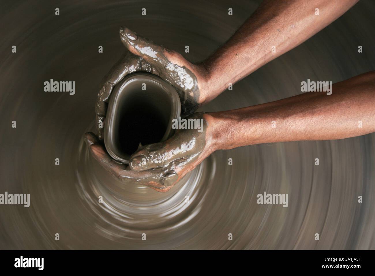 A potter moulding a clay pot on the potter's wheel, Pune, Maharashtra ...