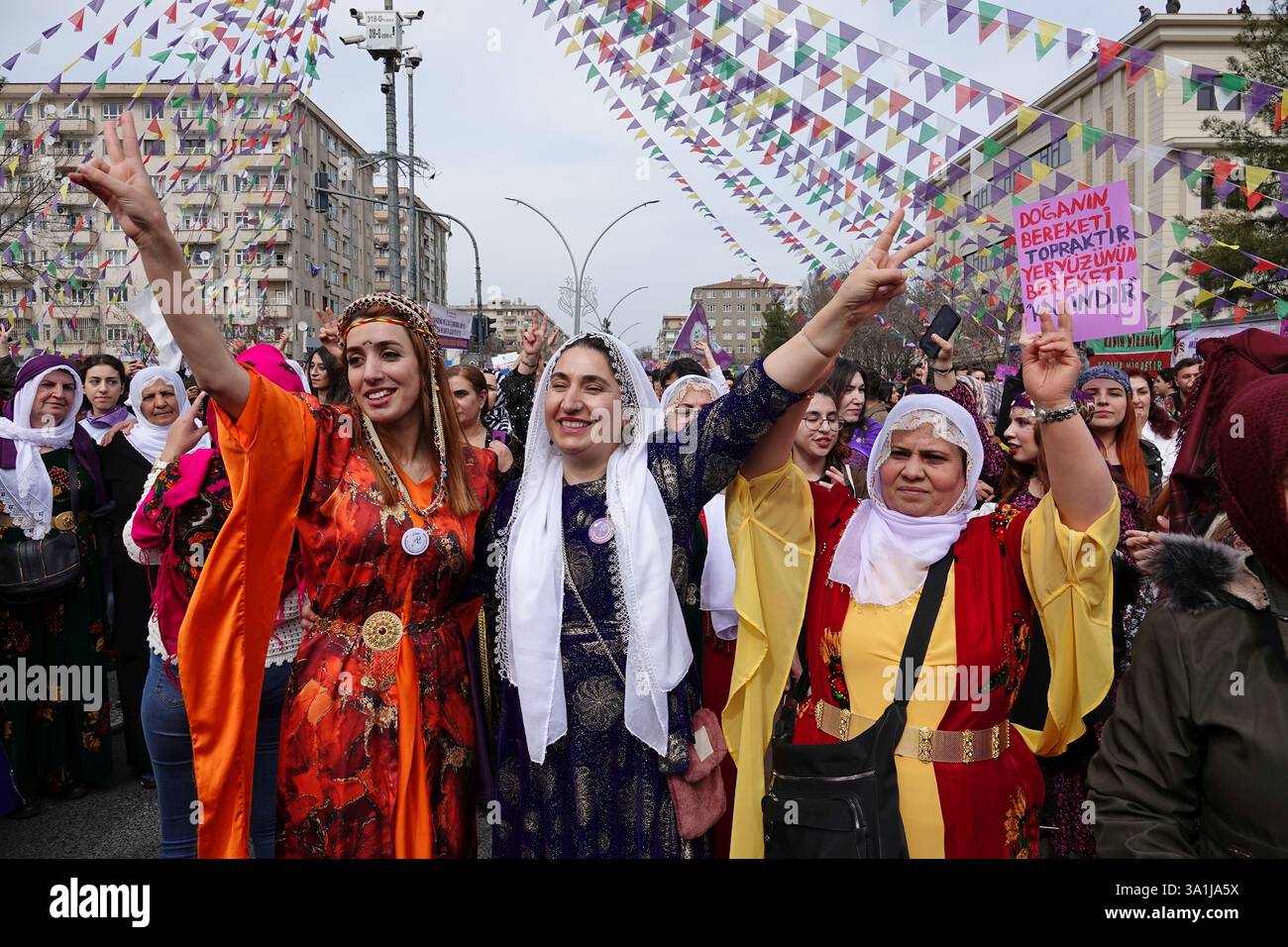 Kurdish women are seen making victory signs at a celebratory rally ...