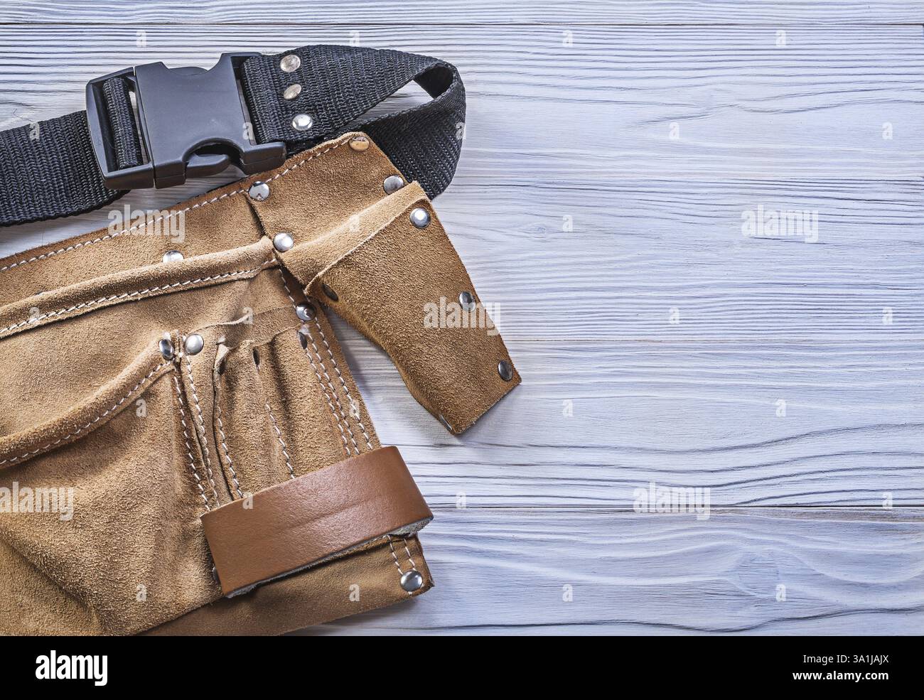 Leather tool belt on wooden board construction concept Stock Photo - Alamy