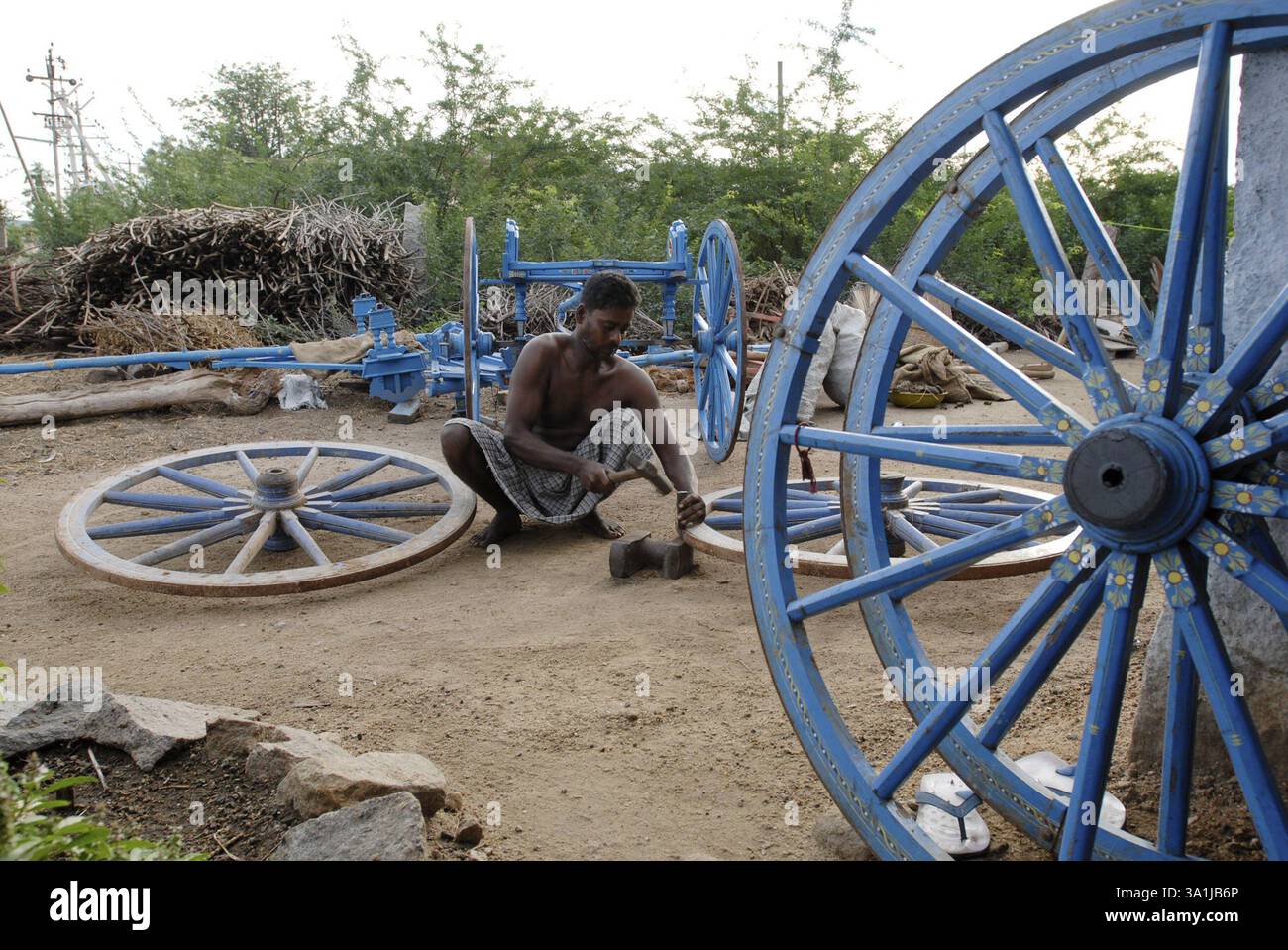 Bullock cart maker, carpenter shaping wheel Stock Photo - Alamy