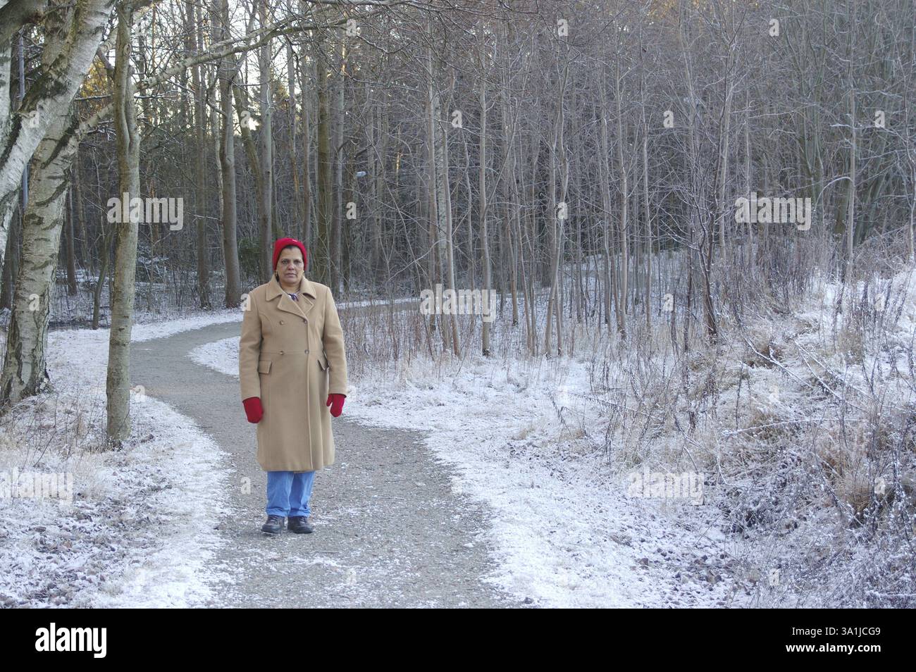 Old lady wearing winter cloths on forest path in Gothenburg, Sweden MR ...